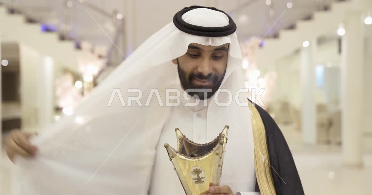A young Saudi Arabian wedding bridegroom performs perfume with incense ...