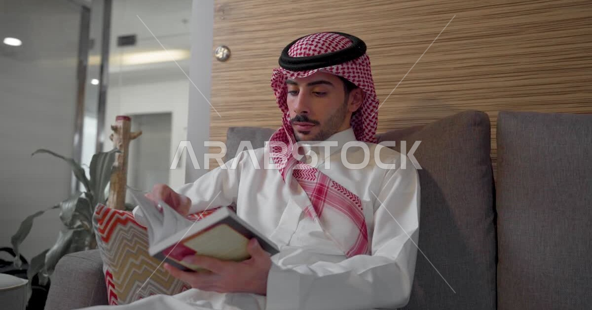 An educated young Saudi Gulf man spends his time in the library ...