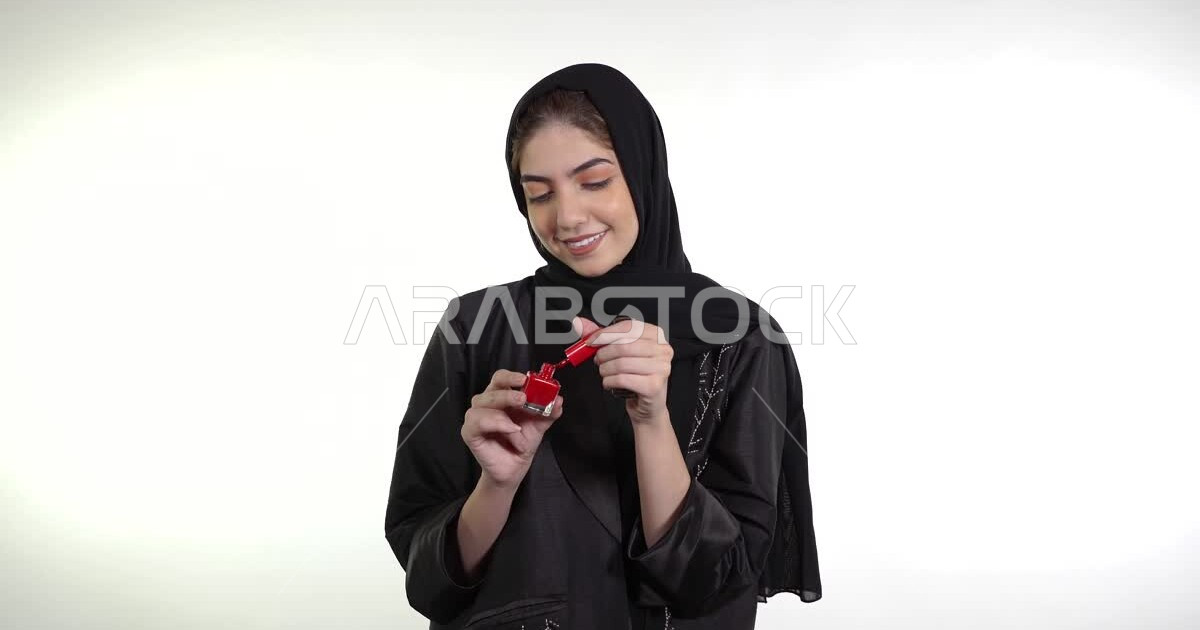 Portrait of a happy Saudi Arabian Gulf woman, who uses a set of ...