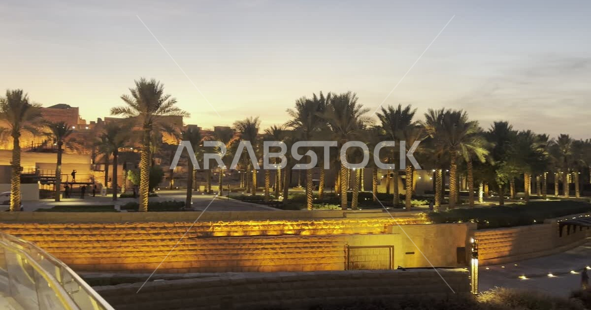 Planting green palm trees, the mud-brick walls of Diriyah at Al-Bujairi ...