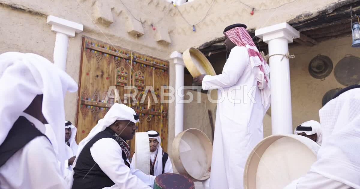 A Saudi Gulf Arab man beating the drum, the Saudi Najdi Ardha band, celebrating the anniversary ...