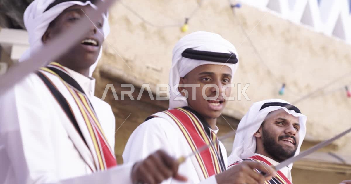 Singing, poetry, and folk dancing with swords, a group of Saudi Gulf ...