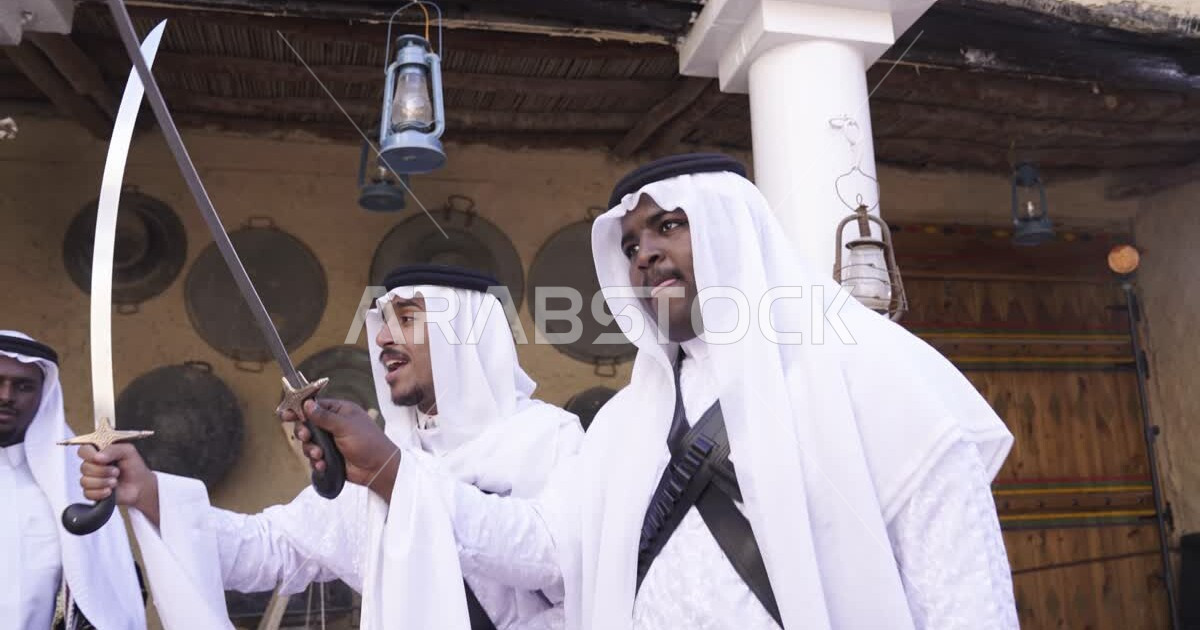 Folk singing and dancing with swords and drums, a group of Saudi Gulf ...