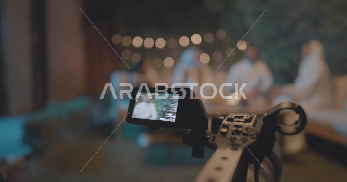 Behind the scenes concept, filming from behind the hand of a Saudi Gulf ...