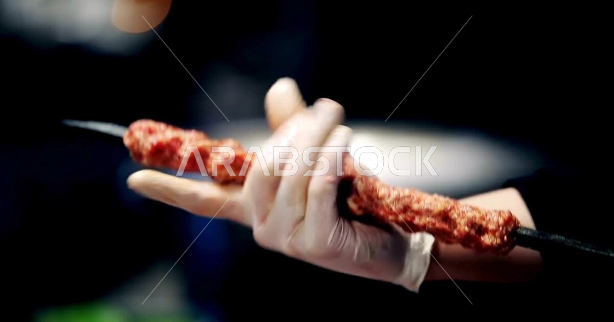 A close-up of a Saudi Arabian Gulf chef forming a skewer (kebab ...