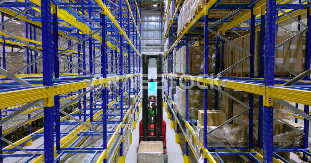 عامل عربي خليجي سعودي يقوم بجر صناديق وكراتين تخزين البضاعة, الطرود ...