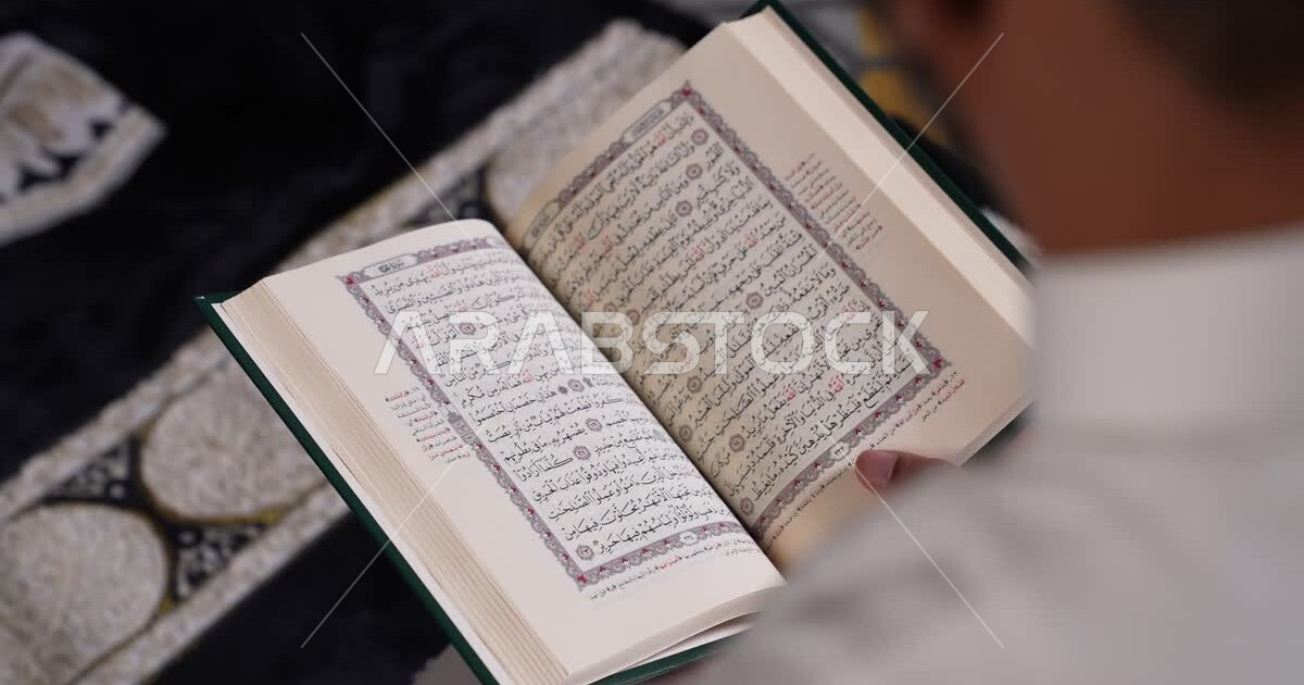 Memorizing and reciting the Holy Qur’an, a close-up picture from behind ...