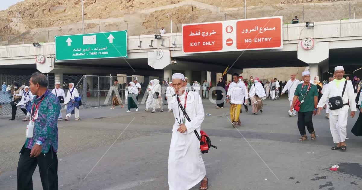 Muslims leaving the Jamarat throwing area, guidance signs on the roads ...