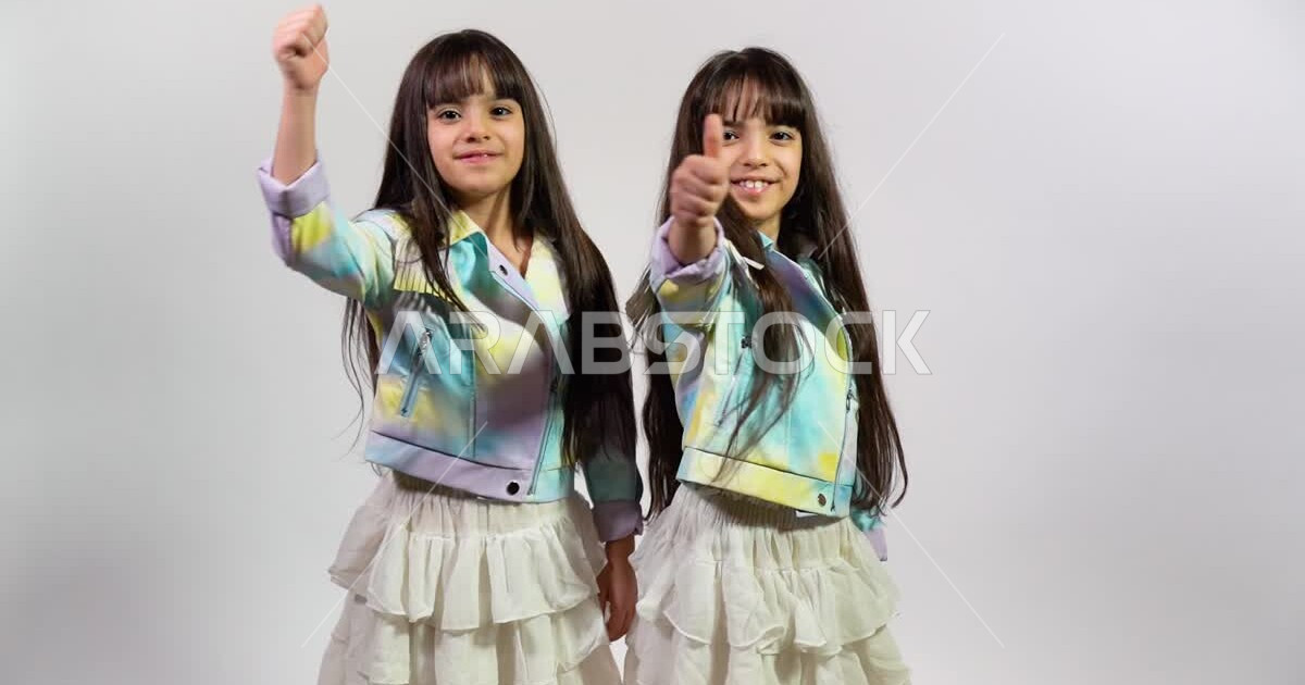Portrait of two similar Saudi twin sisters, wearing beautiful and ...