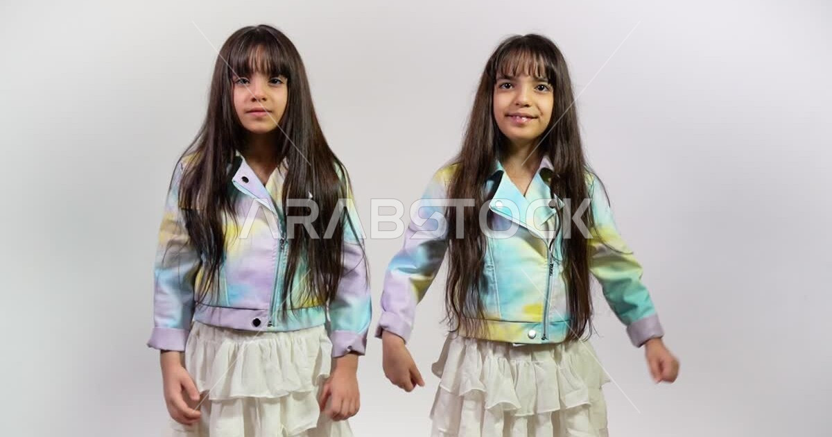Portrait of two similar Saudi twin sisters, wearing beautiful and ...