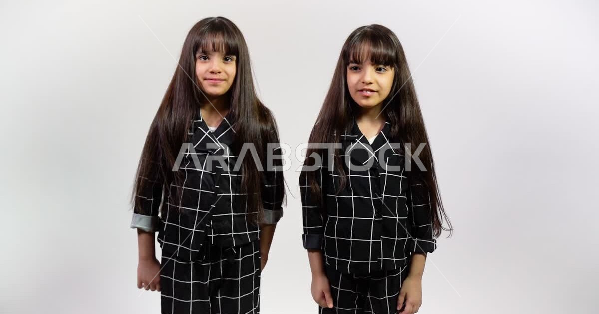 Portrait of two similar Saudi twin sisters, wearing beautiful and ...