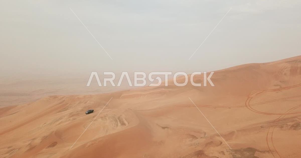 Soft golden sand in the Dahna area, aerial photography of a racing car ...