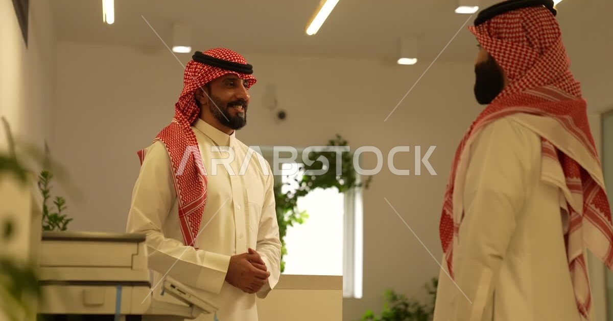 Welcoming, greeting, greetings, two smiling Saudi Gulf Arab men wearing ...