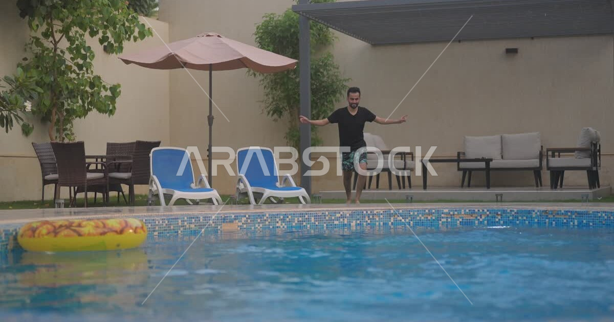 Relaxing and relaxing in the swimming pool, a Saudi Gulf Arab young man ...