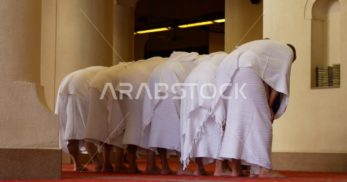 A group of pilgrims and Umrah pilgrims wearing Ihram clothes leaving ...