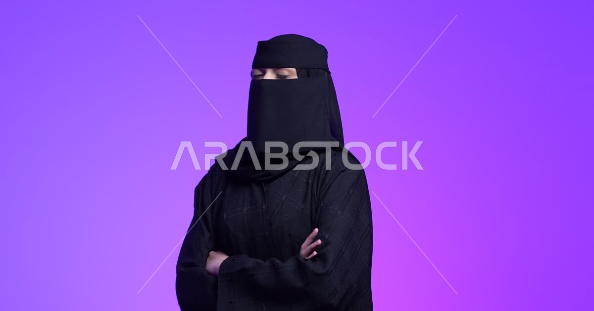 Saudi Arabian Gulf woman wearing abaya and niqab standing with folded ...