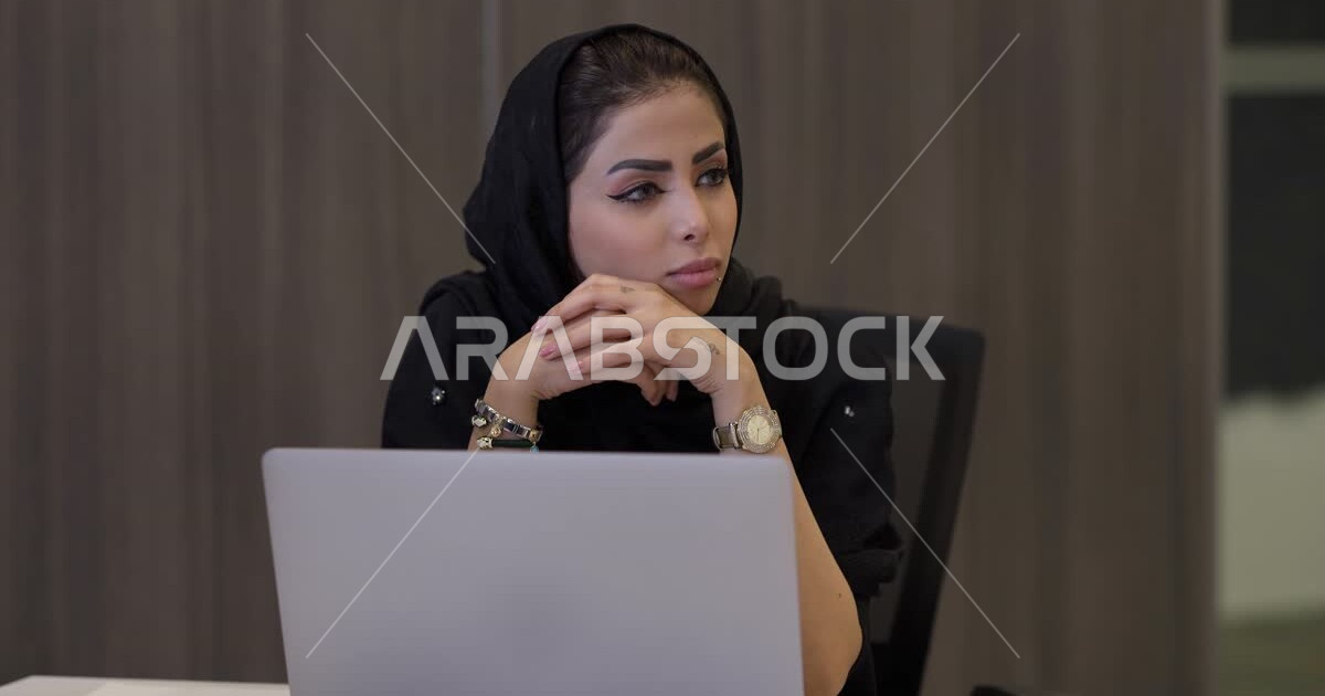 A Saudi Arabian businesswoman working in the office. Using the laptop ...