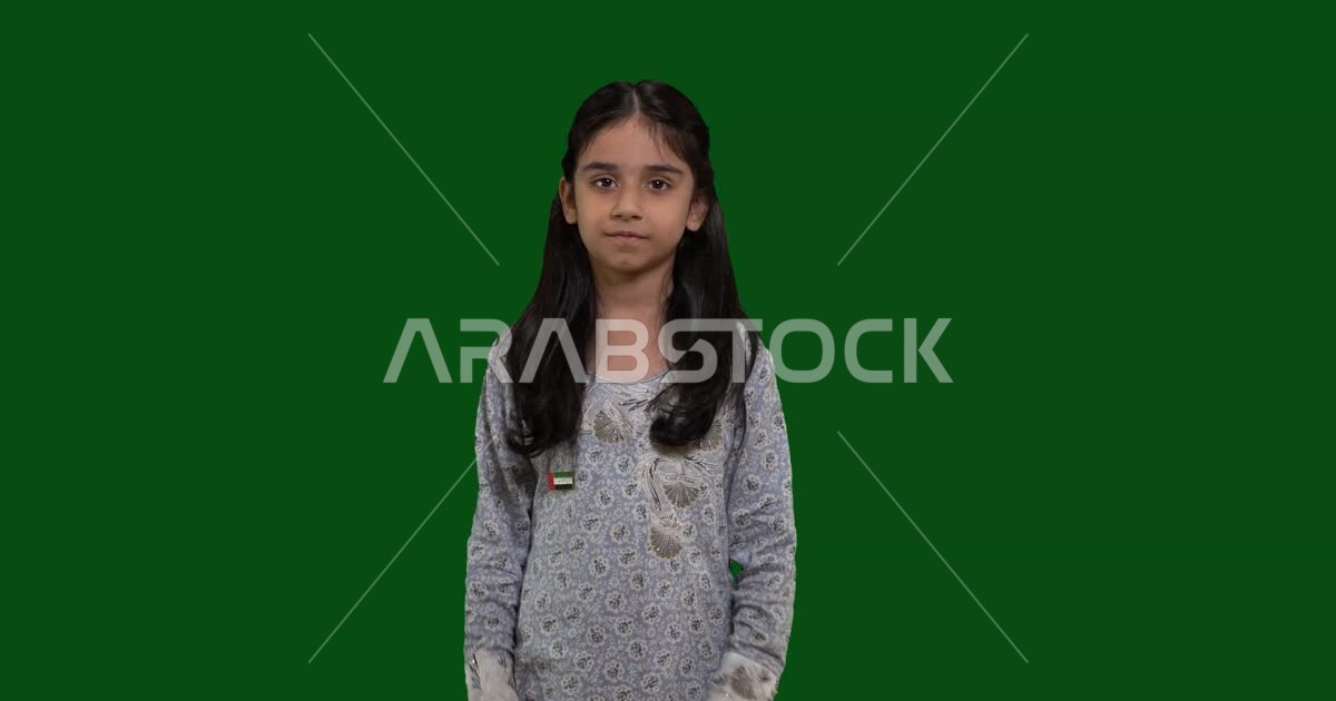 Calling, talking, speaking loudly, an Arab Gulf Emirati girl wearing a ...