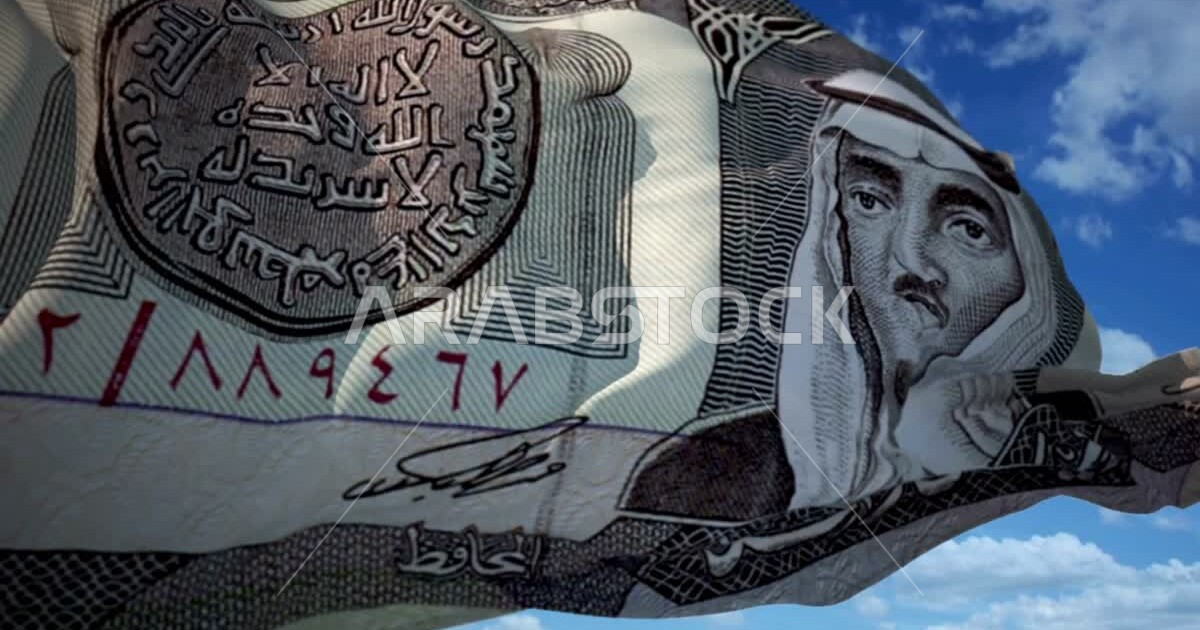 Close-up of Saudi Riyal banknote, fluttering in the sky of the Kingdom ...