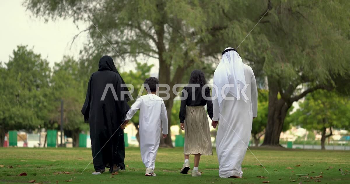 Having fun with kids, photographed from the back, an Emirati Gulf Arab ...