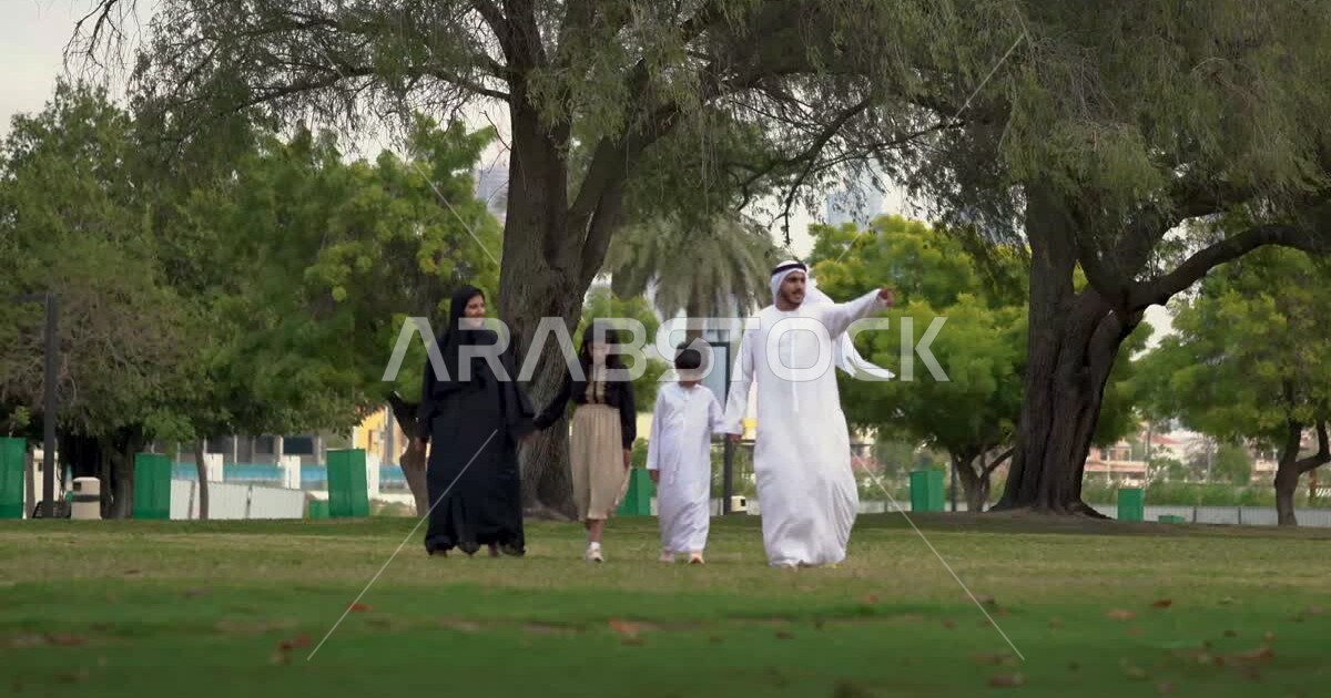 Having fun with kids, an Emirati Gulf Arab family taking a walk in a ...