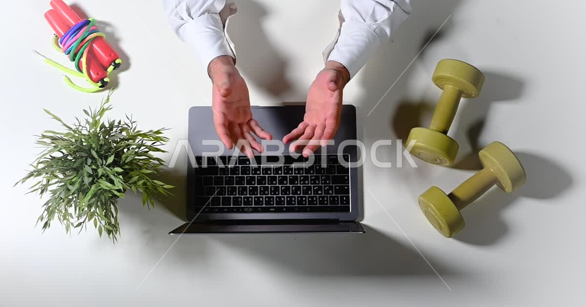 Close up from the top, of a sports coach working on a laptop on a white ...
