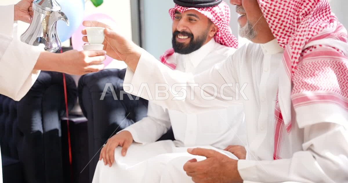 A Saudi Arab woman serves Arabic coffee to the family, sharing a ...
