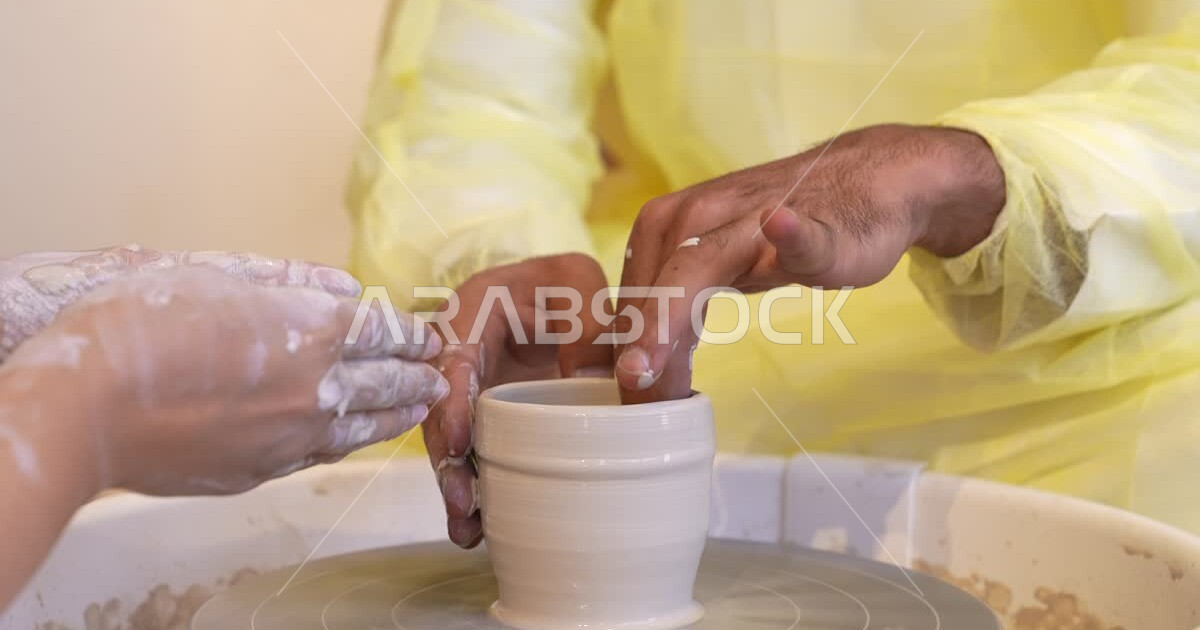 Practicing pottery making skill, close-up of hands of Saudi Arabian ...