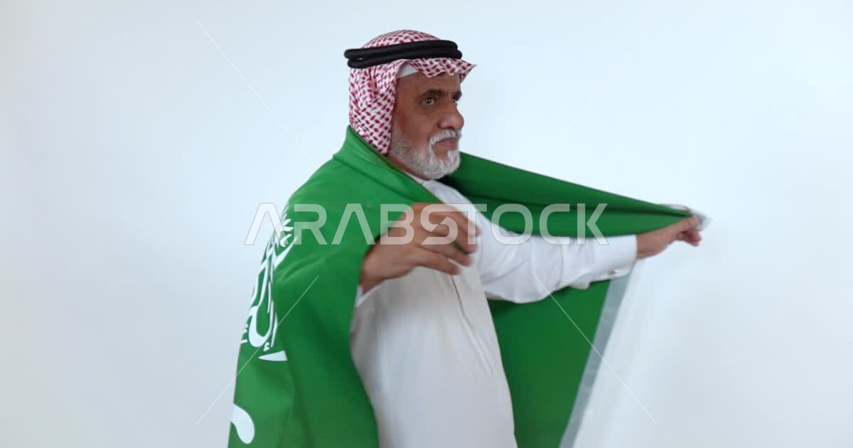Portrait of an old Saudi Arab man putting the flag of Saudi Arabia on ...