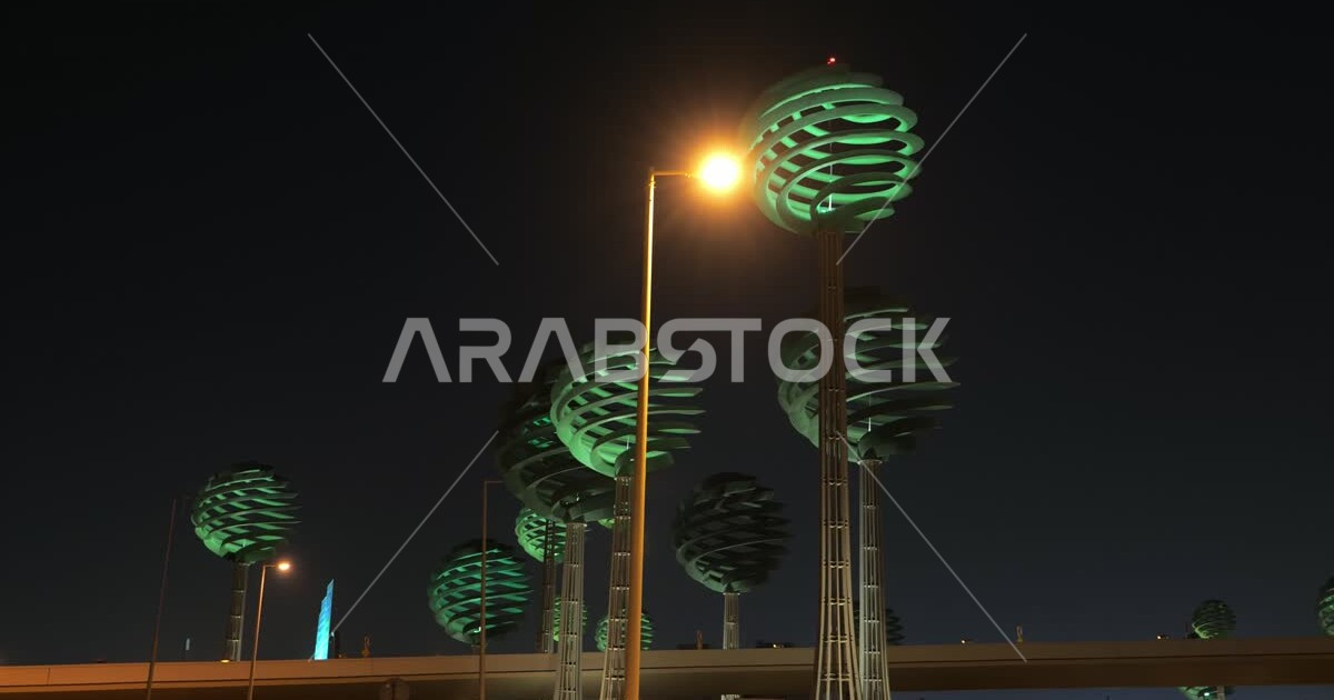 Illuminated art sculptures in the form of green trees at night in Arqa ...