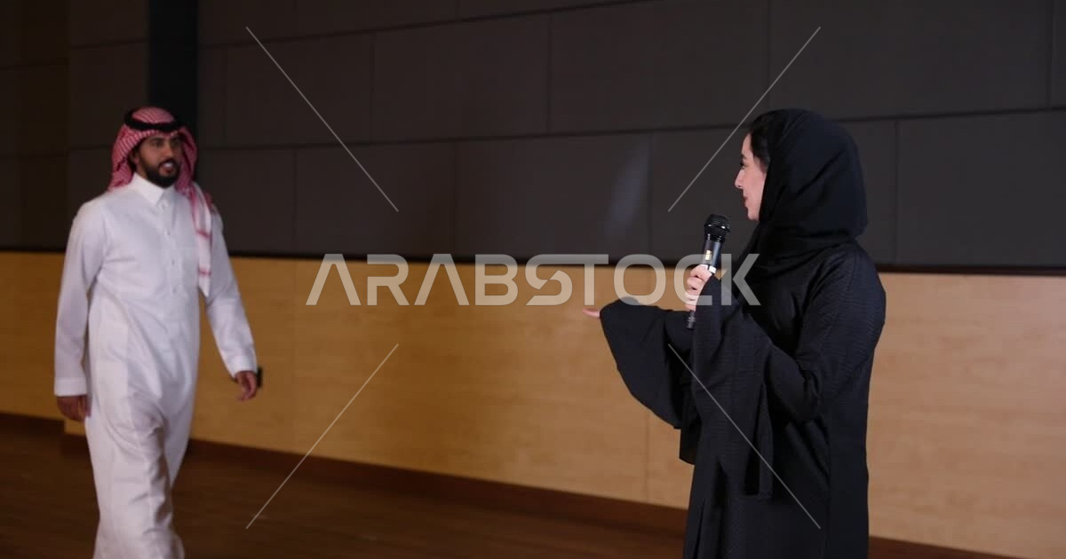 A Saudi Gulf woman and man performing theatrical presentation on stage ...