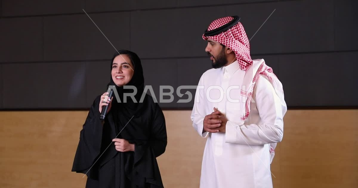 A Saudi Gulf woman and man performing theatrical presentation on stage ...