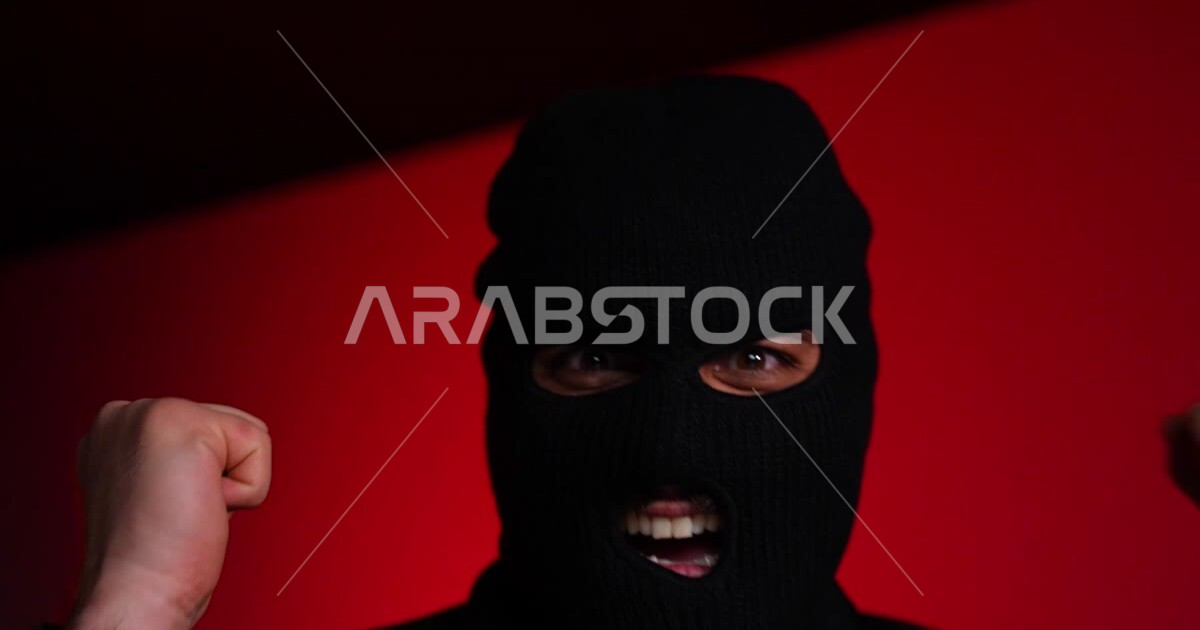 A masked hacker laughing sarcastically, gestures of the face and hands ...