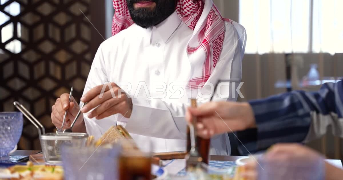 A Saudi Arabian Gulf family sitting in the restaurant, a Saudi Gulf ...