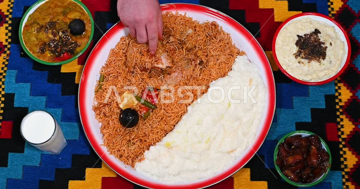 Folk dishes, Saudi Arabian Gulf food, a Gulf Arab man using his hand to ...