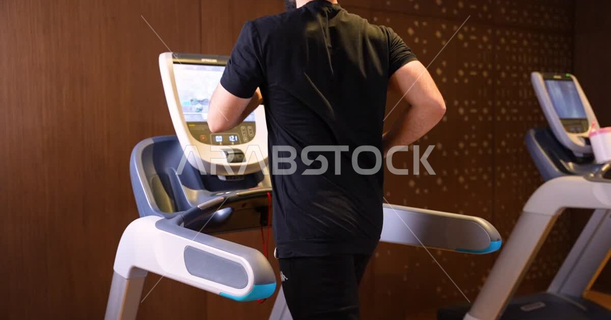 Young Saudi Arab, wearing gym clothes, working out and warming up on ...