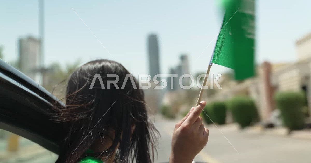 A Saudi Arabian Gulf girl carrying the flag of the Kingdom of Saudi ...