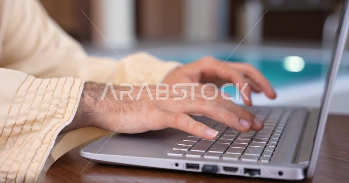 A young Saudi Arab, sitting and relaxing on a chair in the pool, using ...