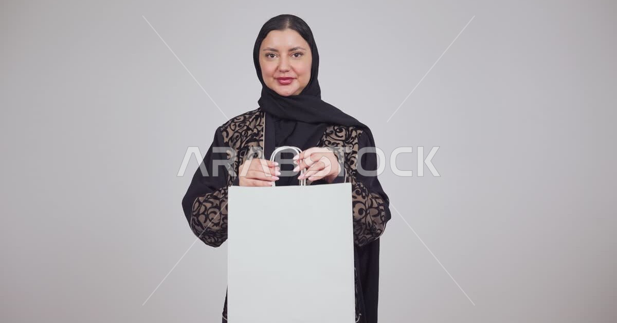 Young Arab Gulf Emirati woman wearing black abaya giving thumbs up ...