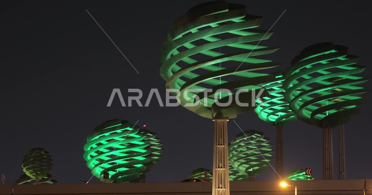 Illuminated art sculptures in the form of green trees at night in Arqa ...