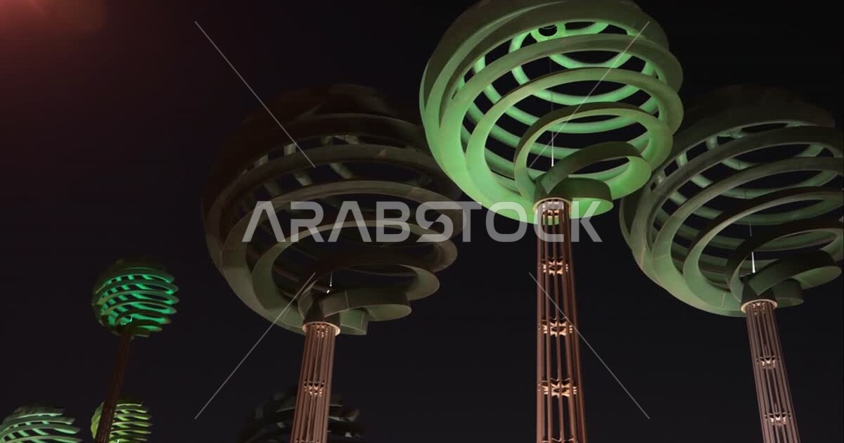 Illuminated art sculptures in the form of green trees at night in Arqa ...