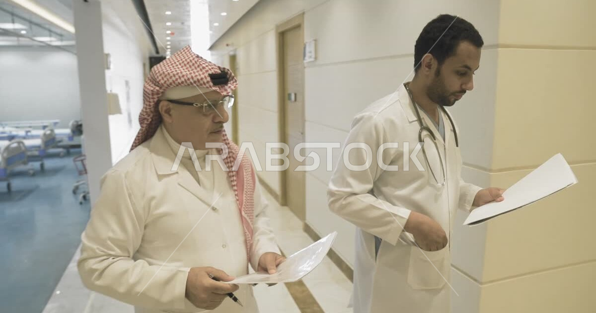 Two Saudi Gulf doctors, working inside the hospital, exchanging medical ...
