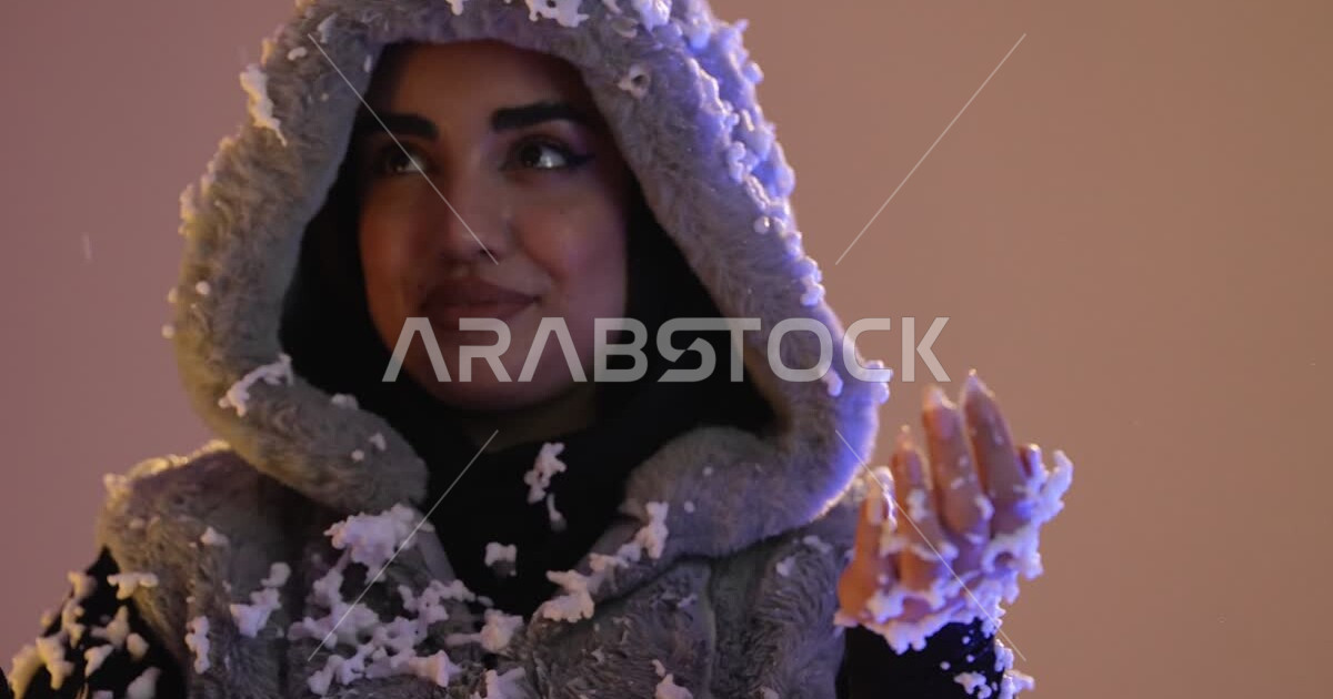 Snow season, young Saudi woman looking with gestures indicating feeling ...