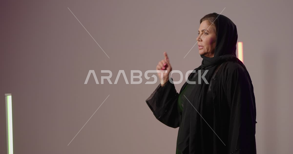 Hand gestures and signs indicating this place (here), a Saudi woman ...