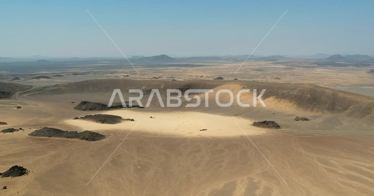 Camera drone flies ahead over a crater in the Harrat Kishb volcanic ...