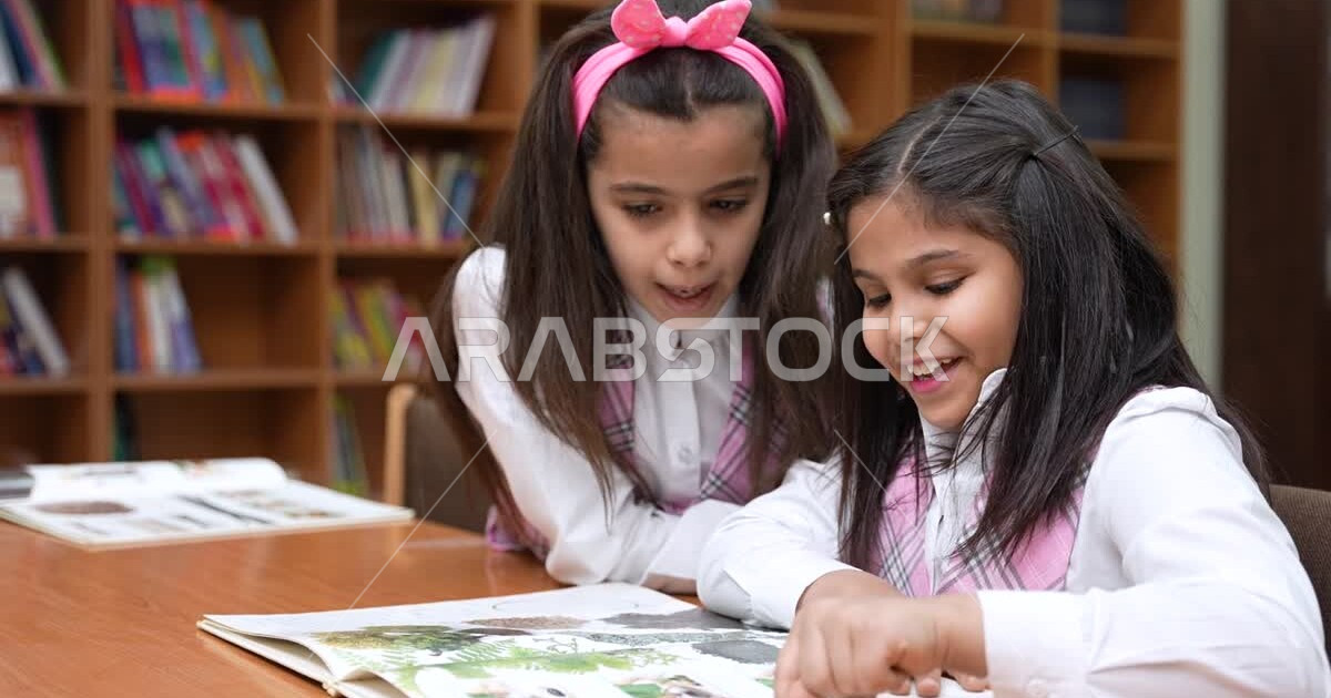 Two Saudi Arabian Gulf students sitting in the school library, enjoying ...