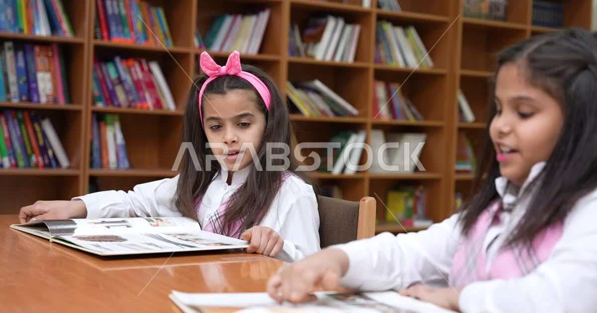 Two Saudi Arabian Gulf students sitting in the school library, enjoying ...