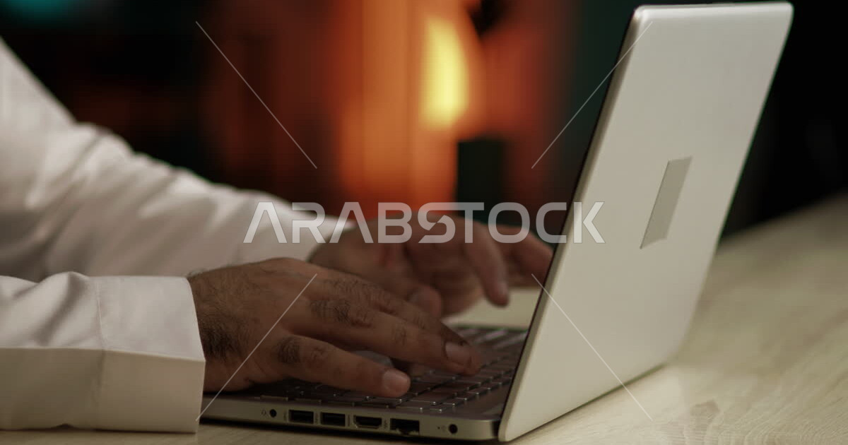 A Saudi Arabian Gulf businessman, using a laptop computer to complete ...
