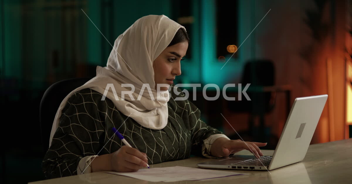 A Saudi Arabian Gulf business woman, using a laptop computer to ...