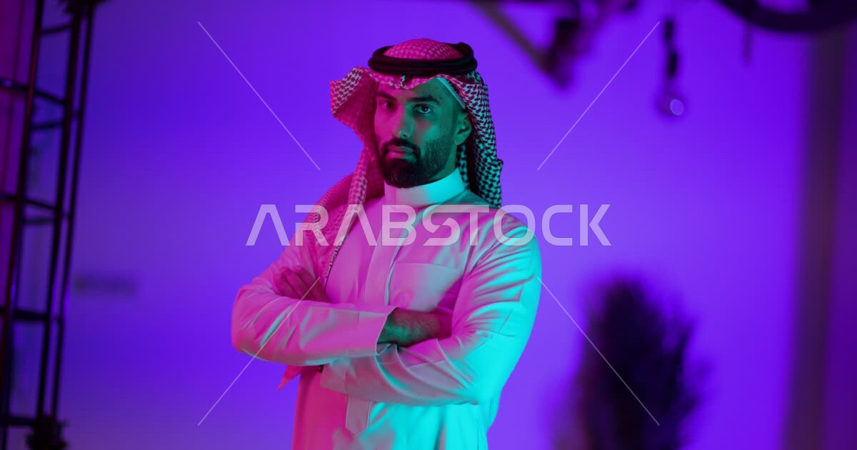 A Saudi Arabian Gulf man, taking a photo session with colored lighting ...